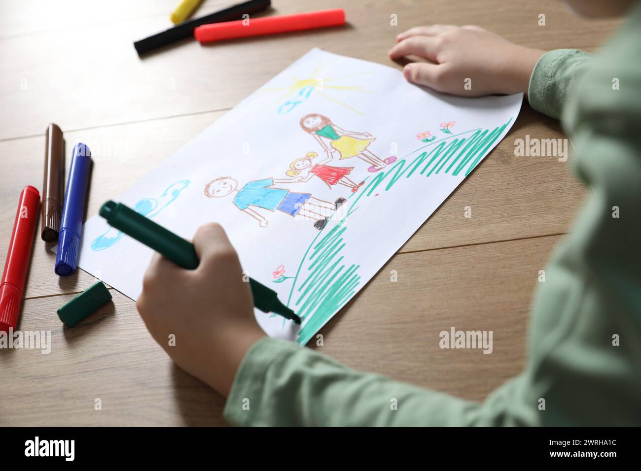 Little boy drawing picture with marker at wooden table, closeup. Child ...