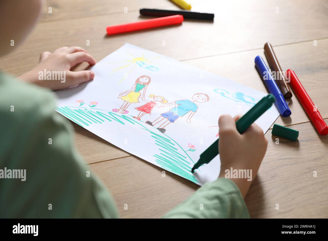Little boy drawing picture with marker at wooden table, closeup. Child ...