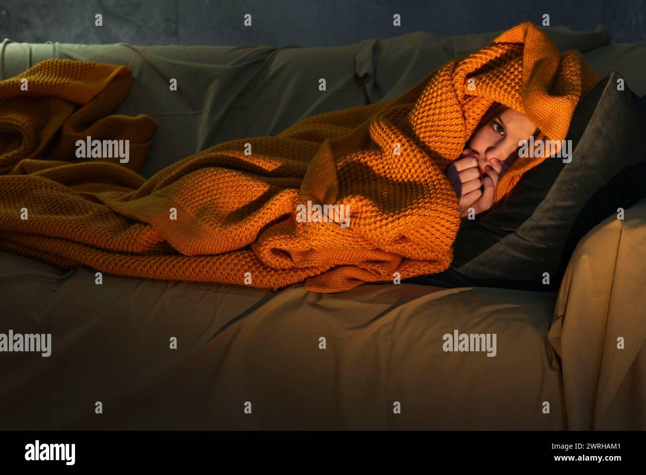 Little girl hiding from monster in blanket on sofa at night Stock Photo ...