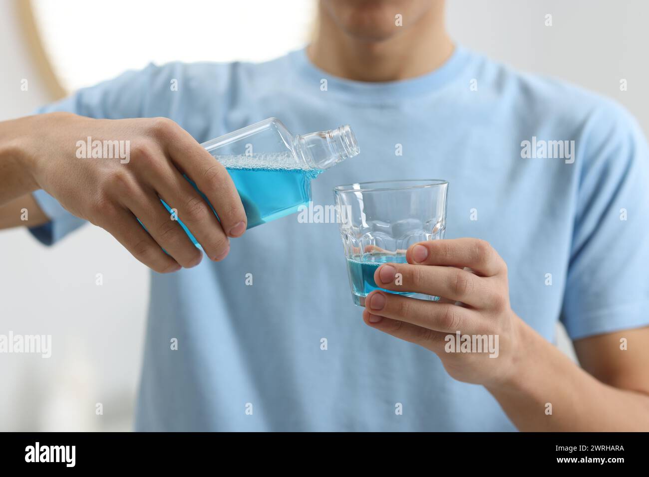 Young man using mouthwash indoors, closeup view Stock Photo - Alamy