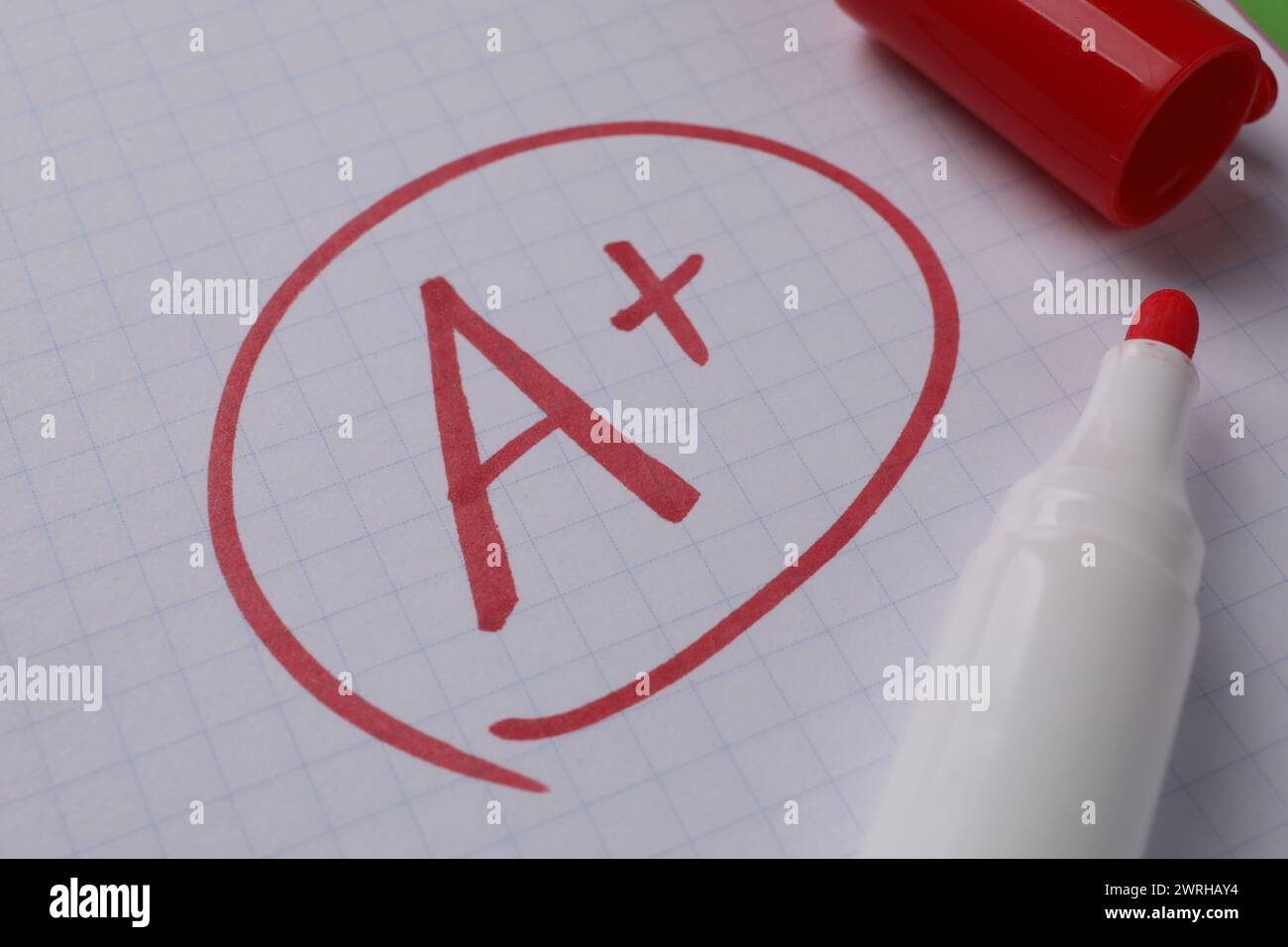School grade. Red letter A with plus symbol on notebook paper and ...