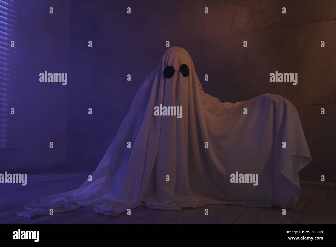 Creepy ghost. Woman covered with sheet in color lights Stock Photo - Alamy