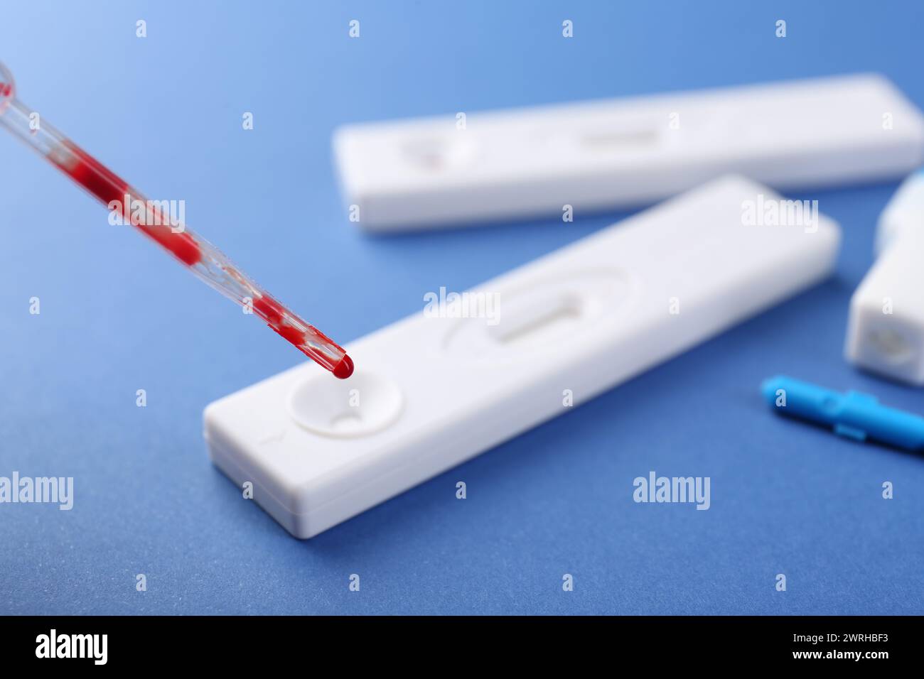 Dropping blood sample onto disposable express test cassette with ...