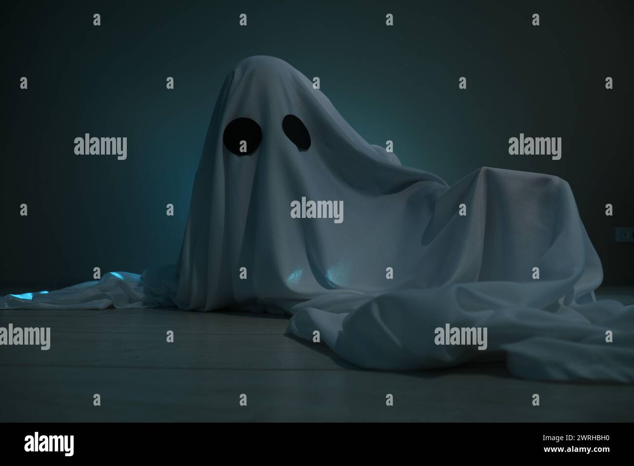 Creepy ghost. Woman covered with sheet on dark teal background Stock ...