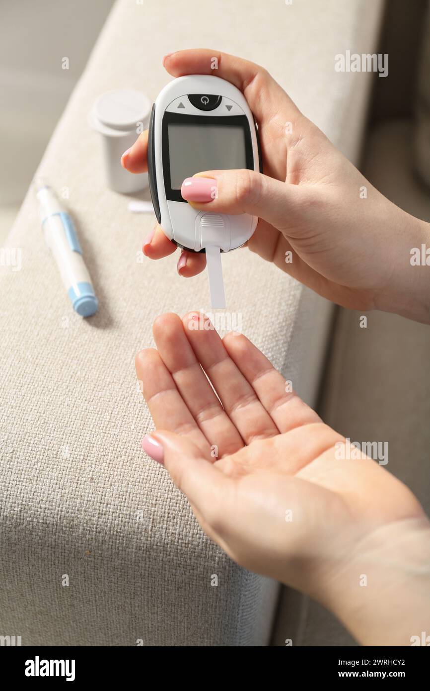 Diabetes. Woman checking blood sugar level with glucometer at home ...