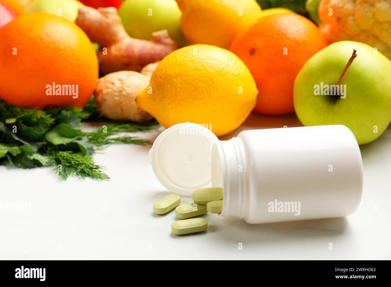 Dietary supplements in plastic bottle and products on white table ...