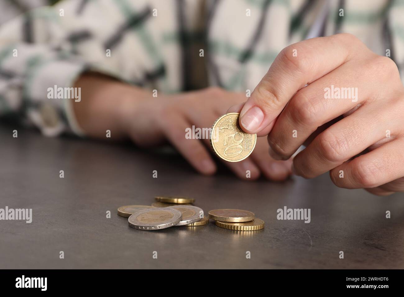 Poor woman counting coins at grey table, closeup Stock Photo - Alamy