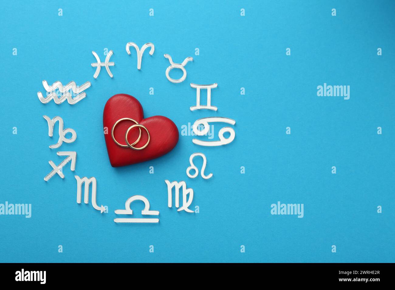 Zodiac signs, heart and wedding rings on light blue background, flat ...