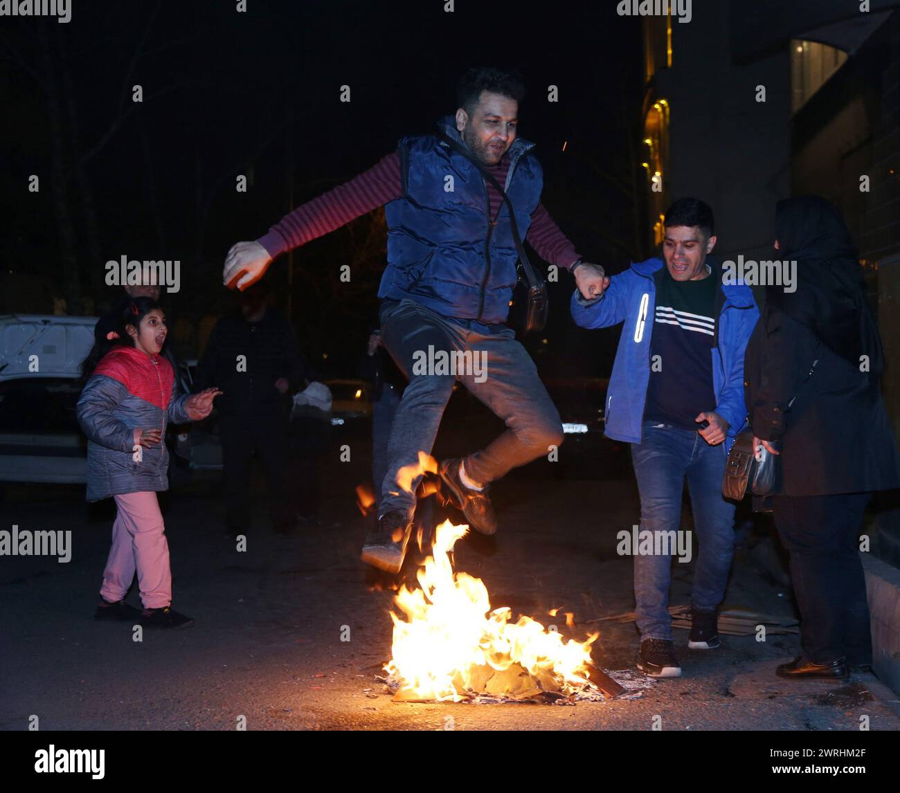 Tehran, Iran. 13th Mar, 2024. A man jumps over a bonfire during the ...
