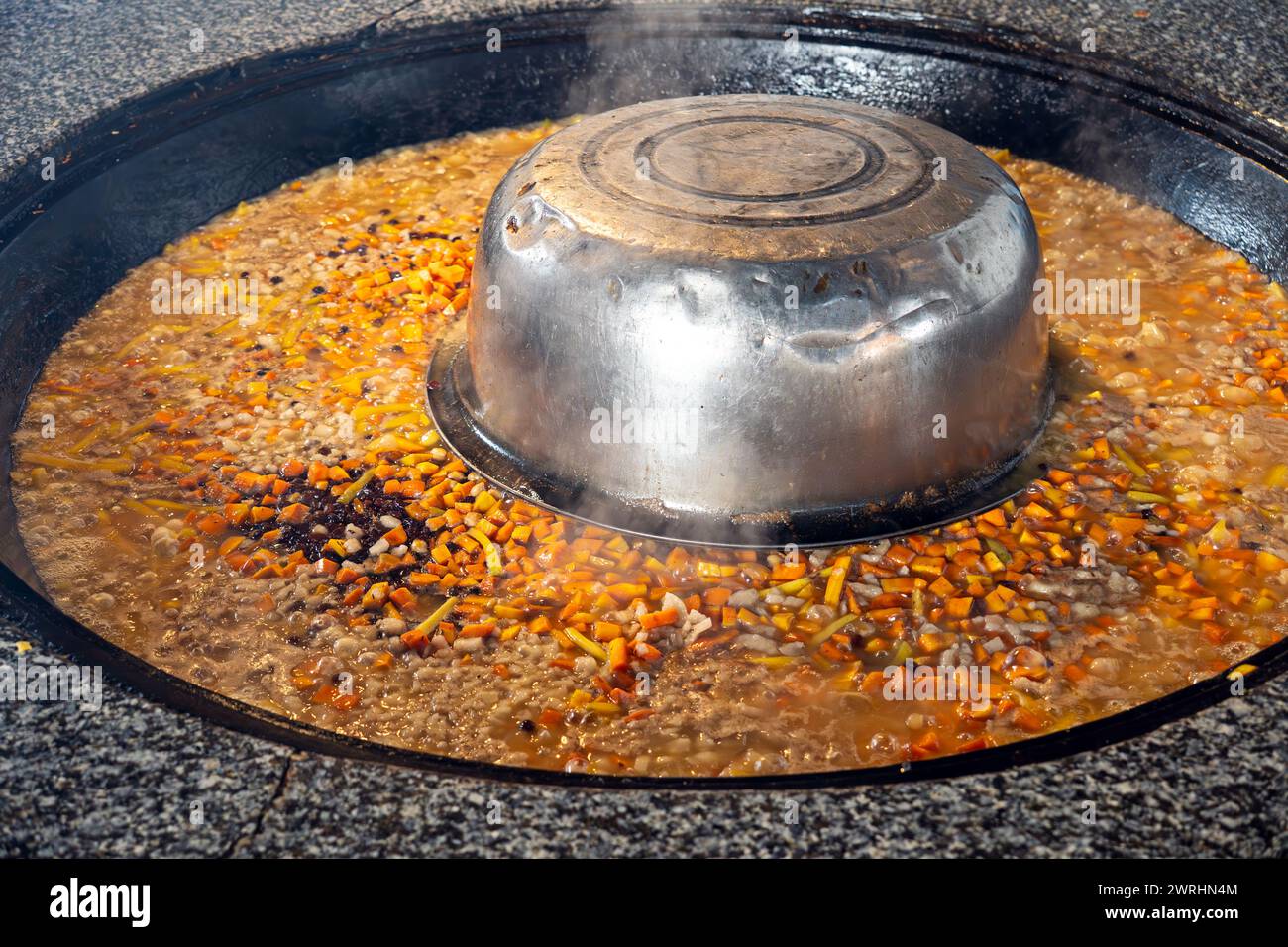 Hot pilaf in large cauldron outdoors. Traditional oriental food. Street ...