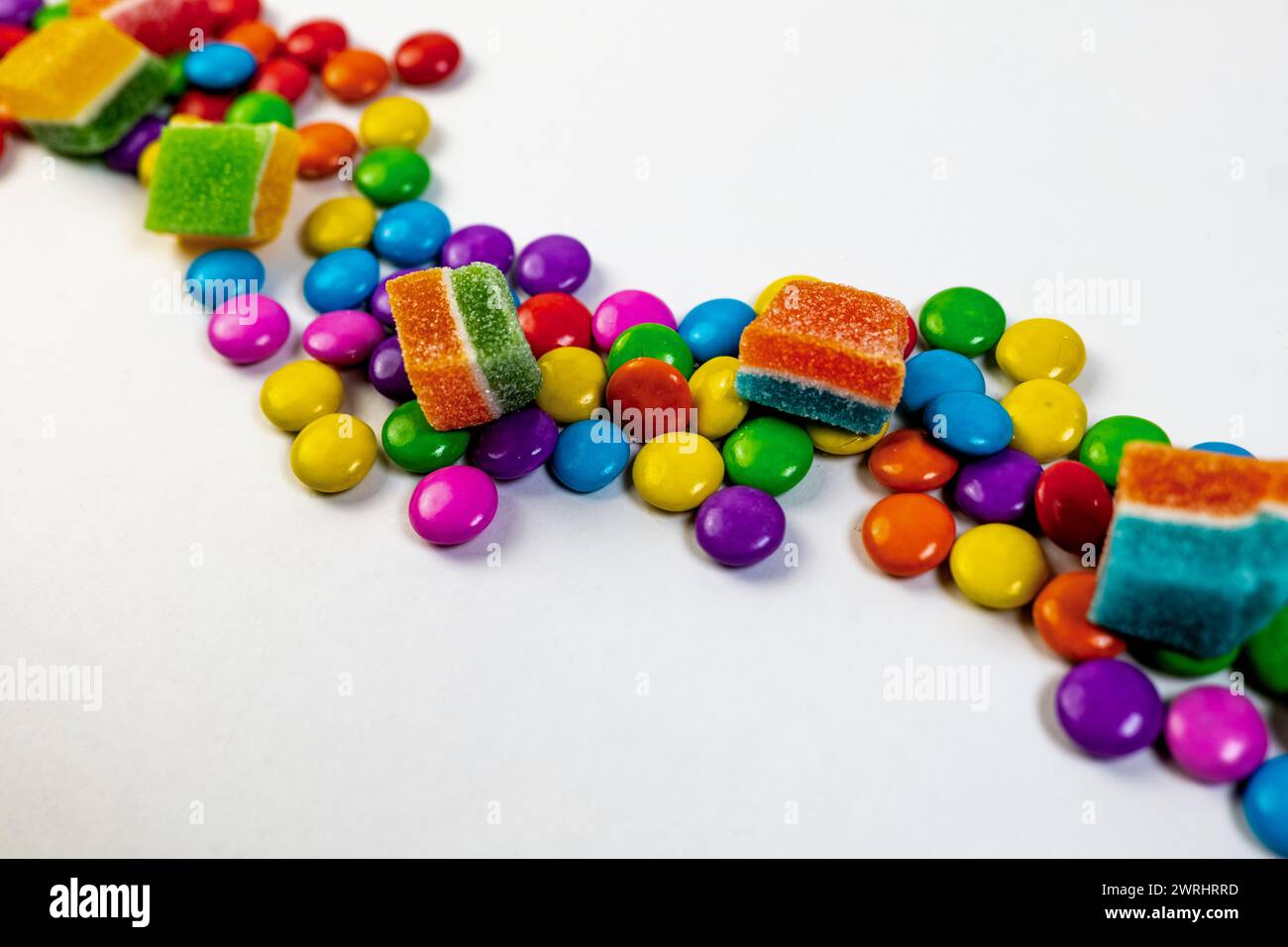 A burst of colorful candies in various shapes and sizes, scattered ...