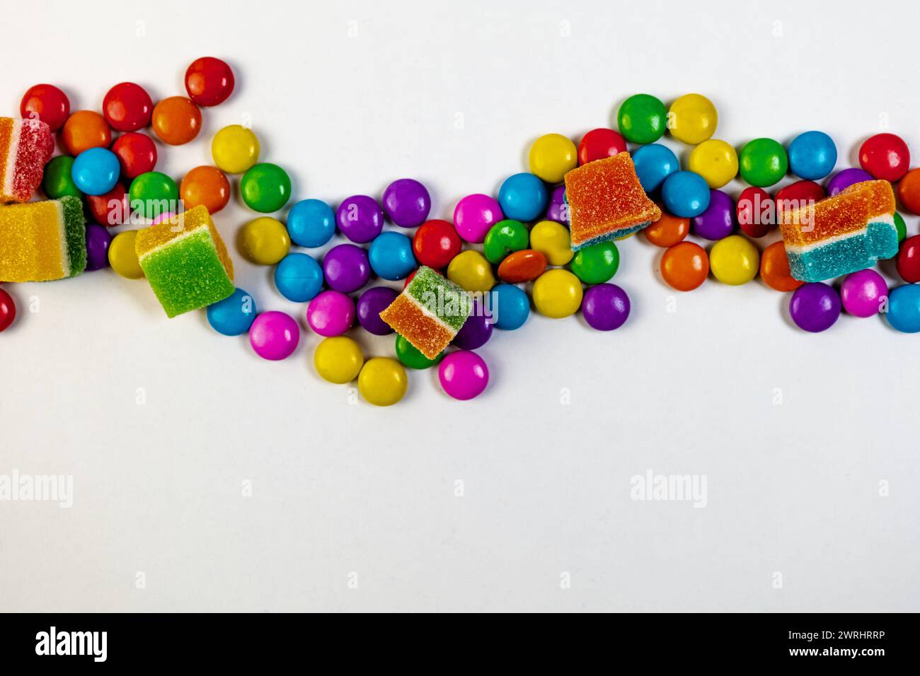 A burst of colorful candies in various shapes and sizes, scattered ...