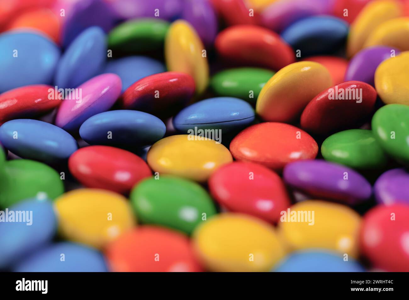 A macro photograph showcasing a variety of colorful chocolate candies ...
