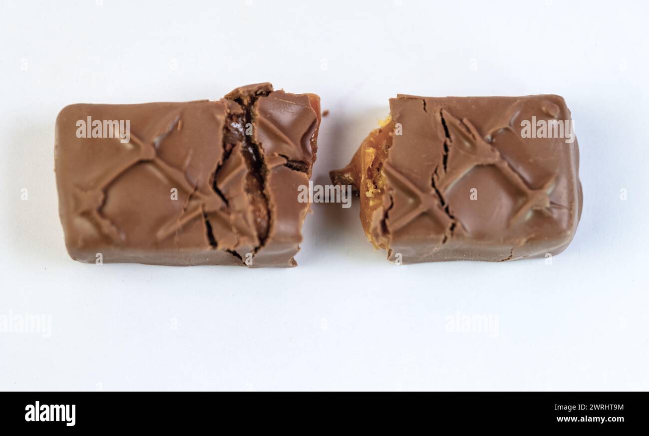 A single chocolate bar, bathed in warm light with a blurred background ...
