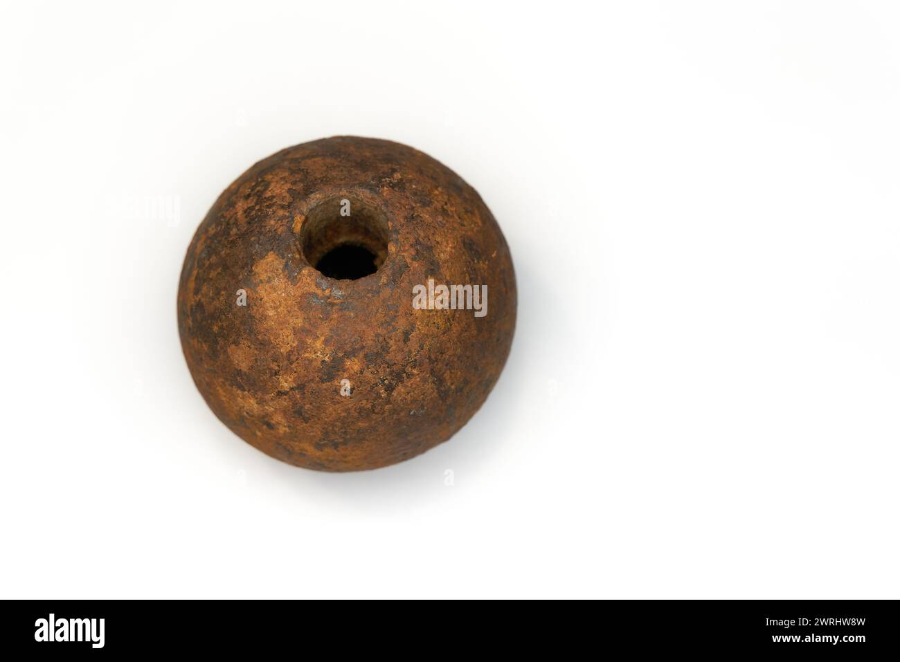 Rusted cannonball from a historical battlefield in Germany with a white ...