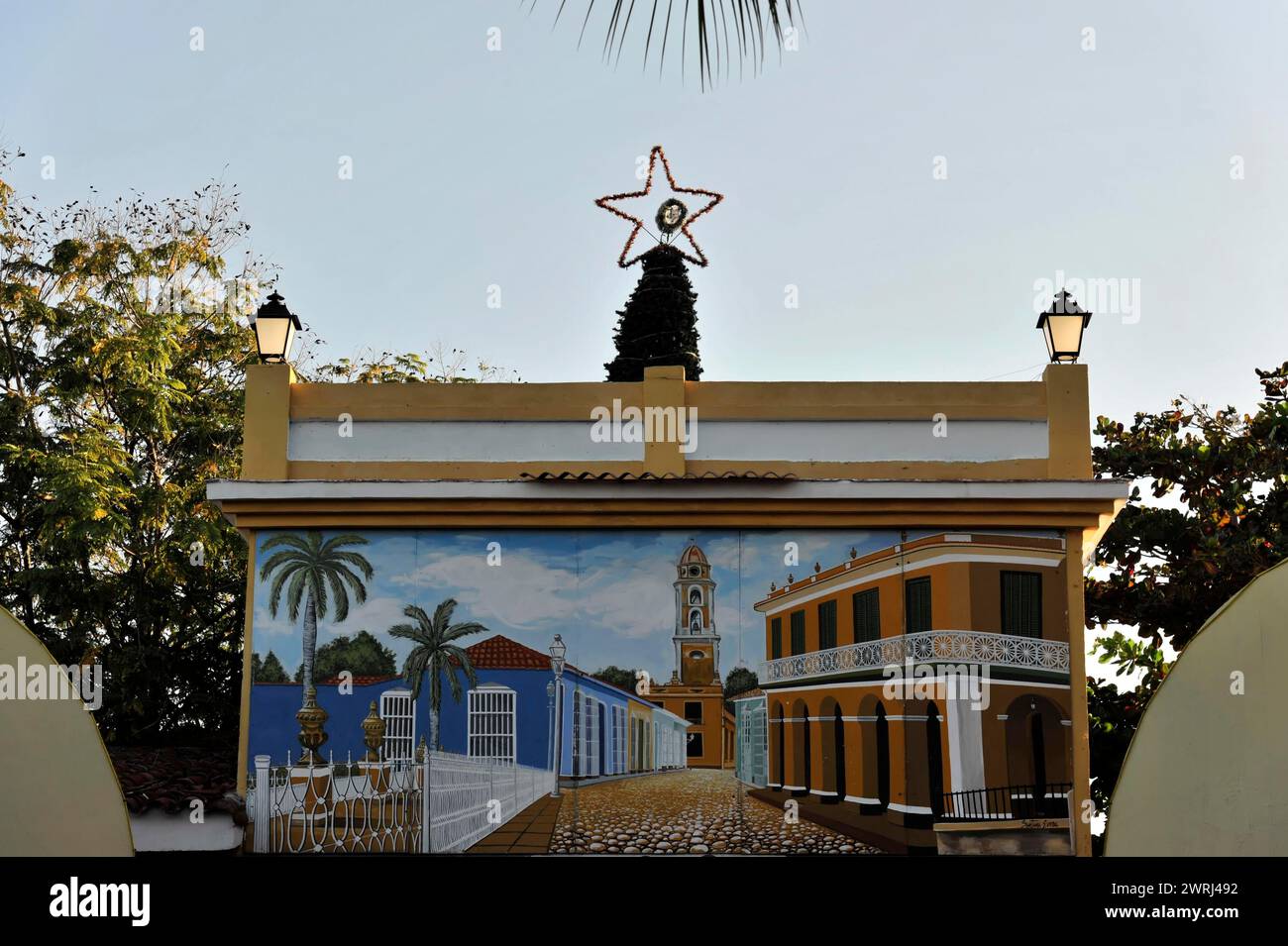 A painted depiction of a Cuban street scene with architecture and sky ...