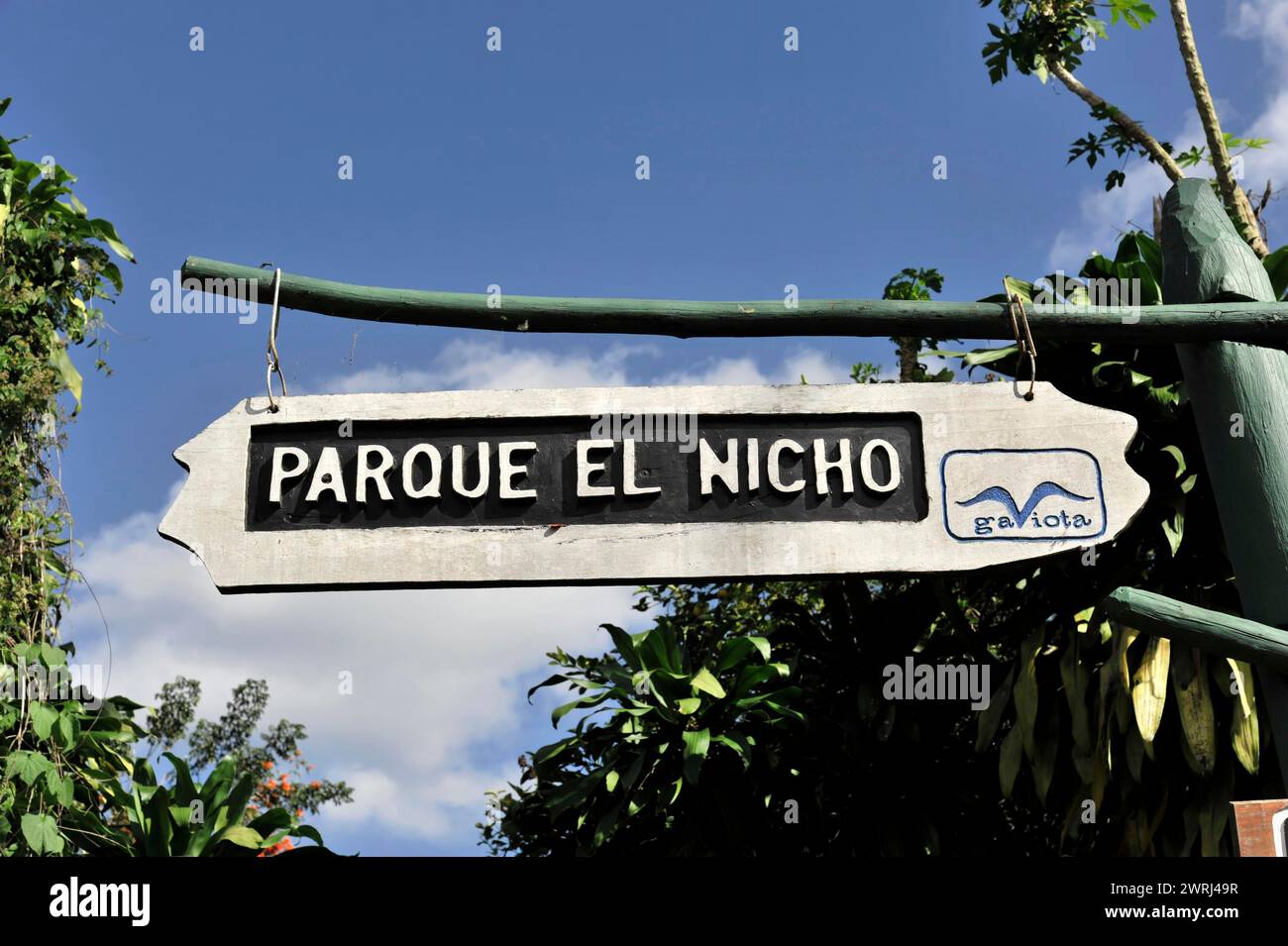 A sign points the way to Parque El Nicho against a blue sky, PARQUE EL ...