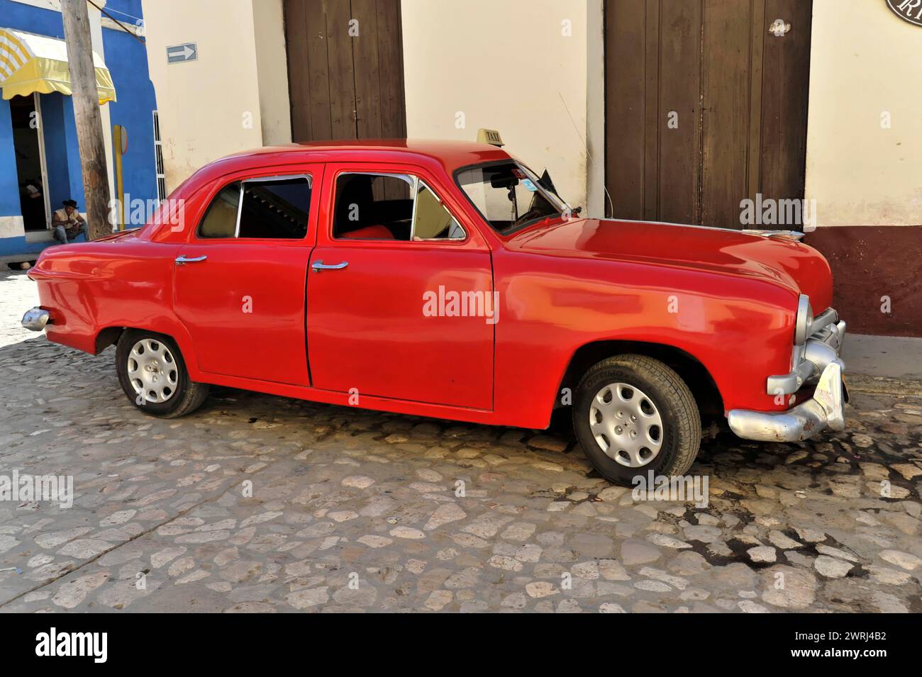 Red classic car sideways on an urban background, Trinidad, Cuba ...