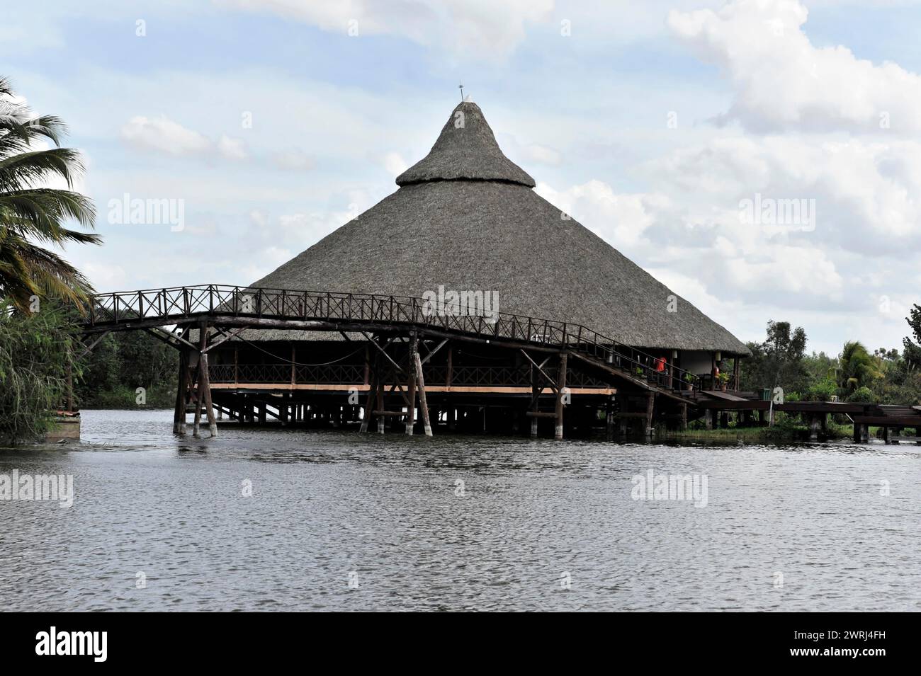 Traditional hut with thatched roof over the water with bridge access ...