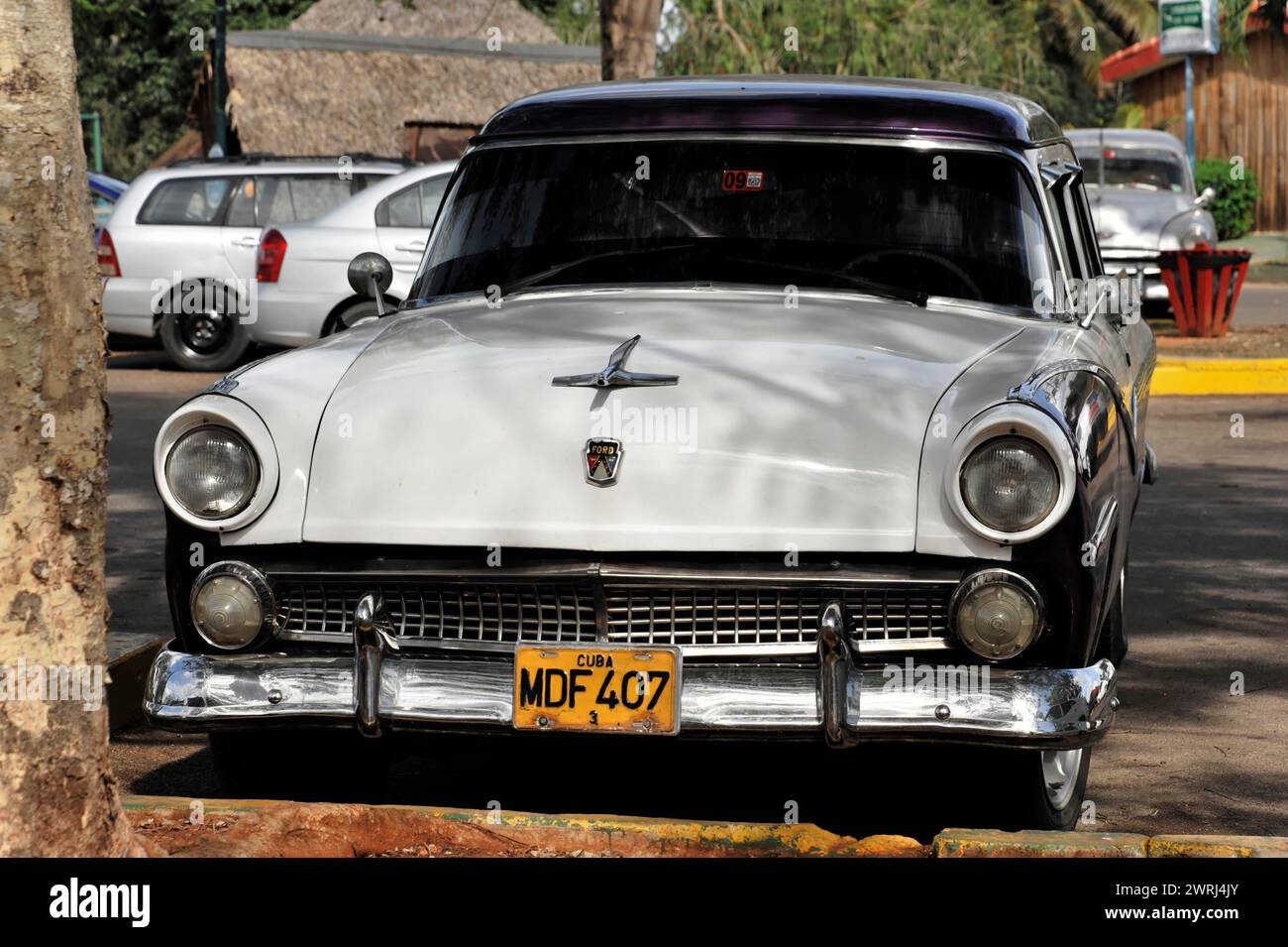White vintage car with chrome details parked in a Cuban car park, front ...