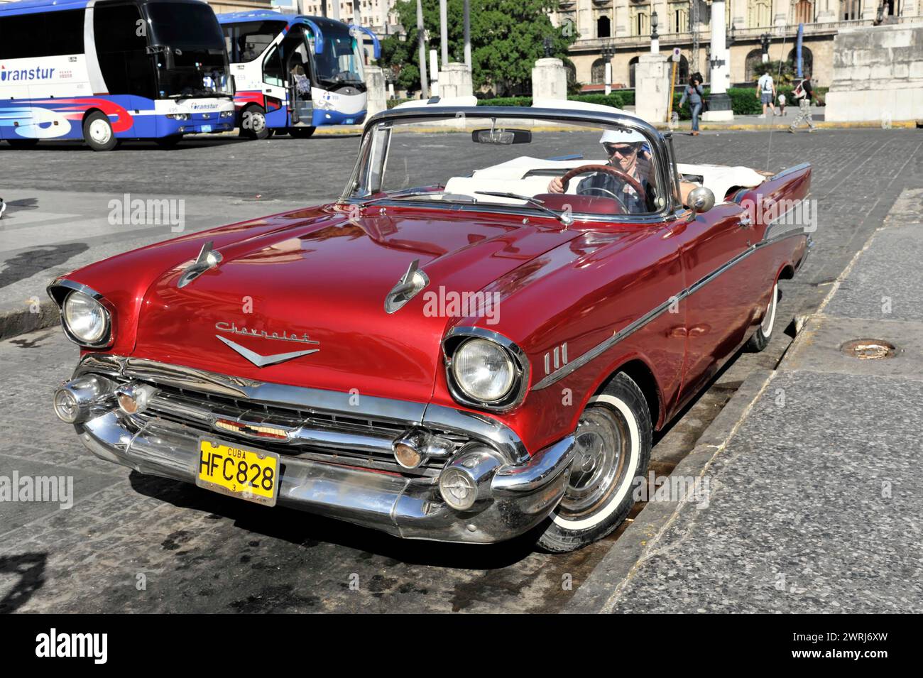 Red convertible vintage car parked on an urban street with palm trees ...