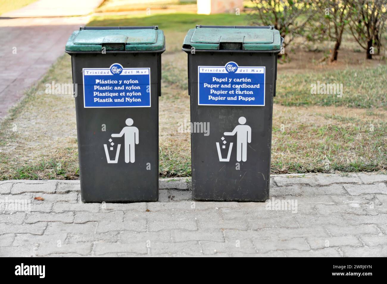 Two rubbish bins for recycling standing next to each other on a path ...