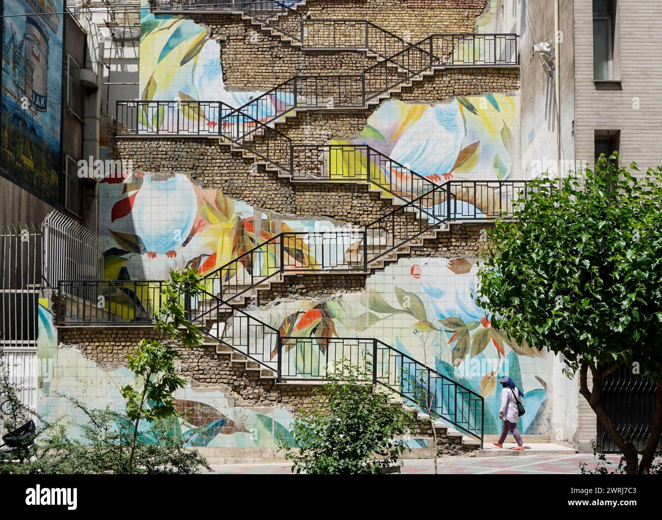 Passers-by walk up a staircase painted with roses in Tehran. The city ...