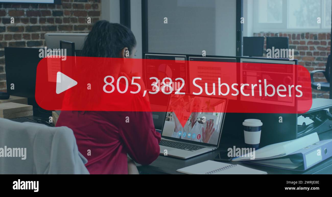 Young Asian woman monitors subscriber count at her workstation. She ...