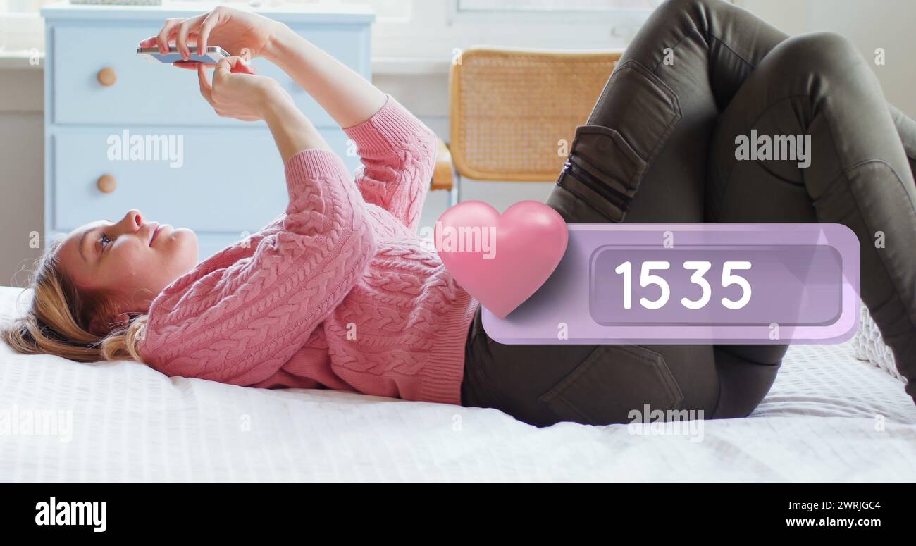 Woman on bed types on phone as heart count rises Stock Photo - Alamy