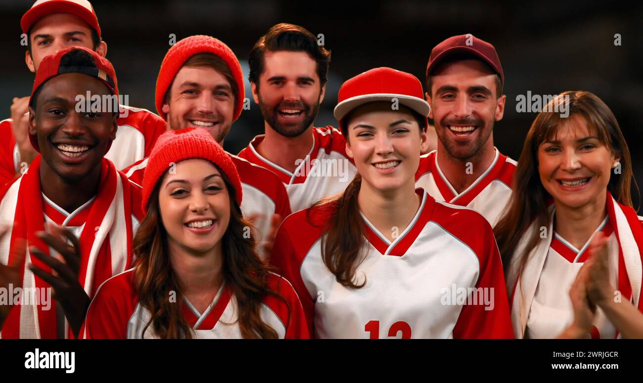 Front view of sports fans, wearing white and red jerseys, cheering as a ...