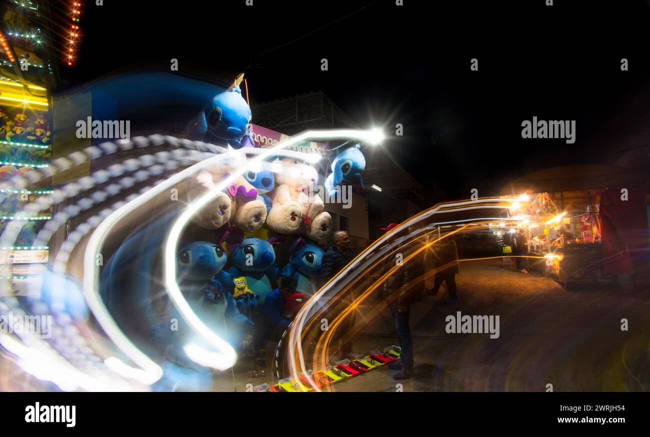 A Mexican fair with rides and lights at night, with space for text ...