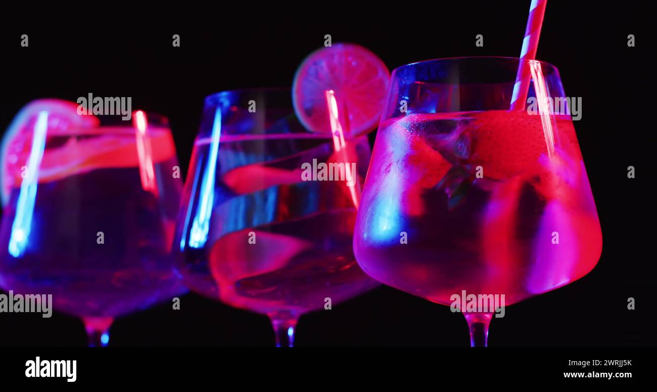 Glasses filled with vibrant drinks glow under neon lights Stock Photo ...