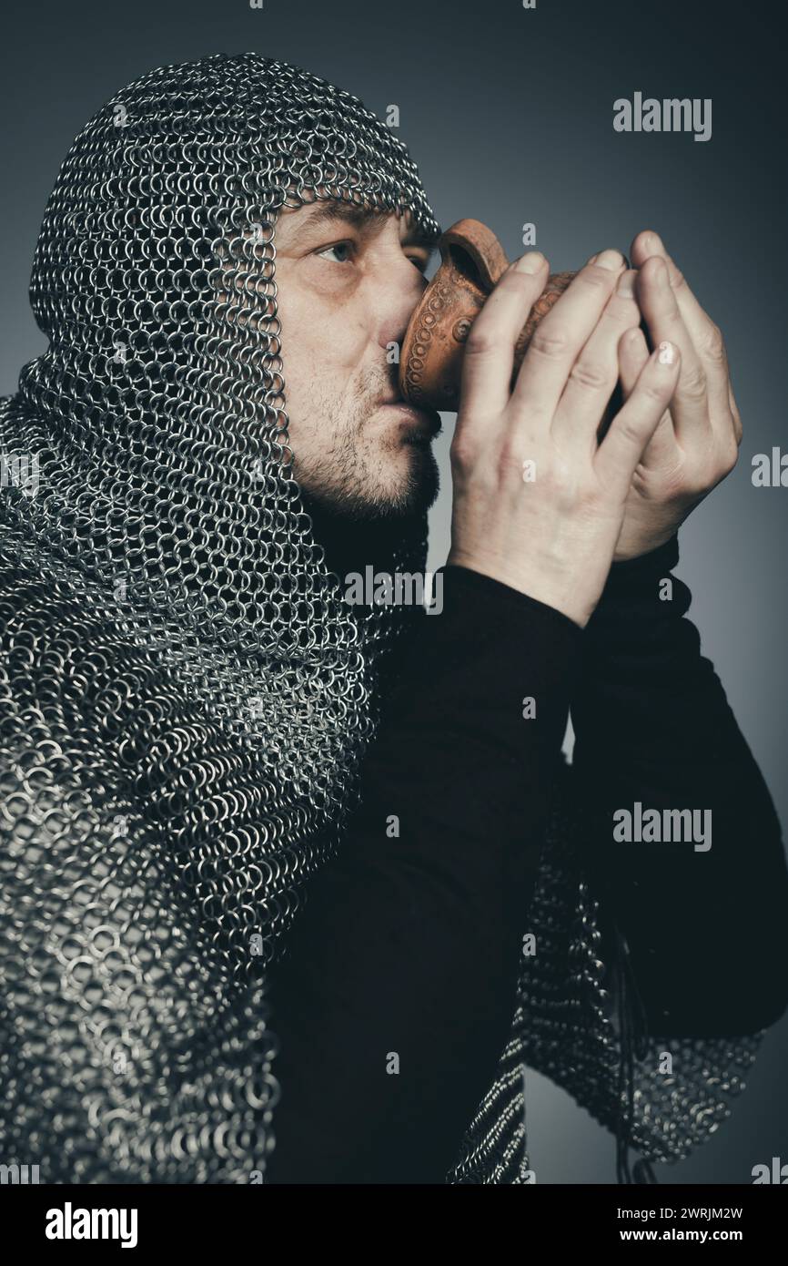 Medieval infantry armed man dressed in chain armor holding clay jug ...