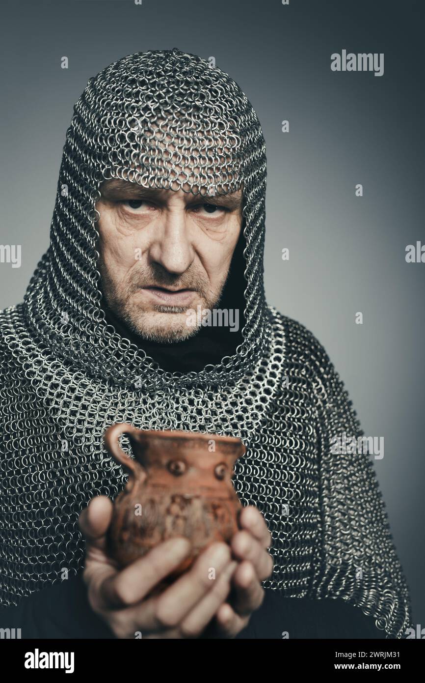 Medieval infantry armed man dressed in chain armor holding clay jug ... Medieval infantry armed man dressed in chain armor holding clay jug ...