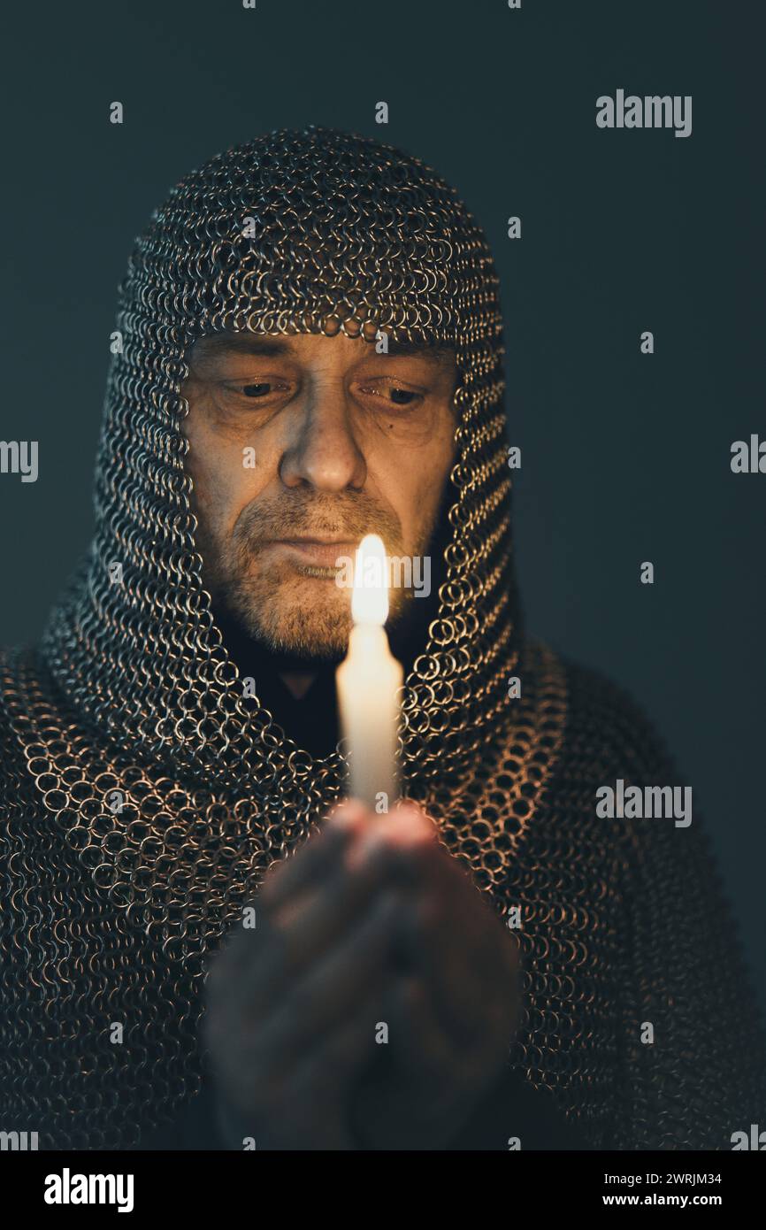 Medieval infantry armed man dressed in chain armor holding wax candle ...