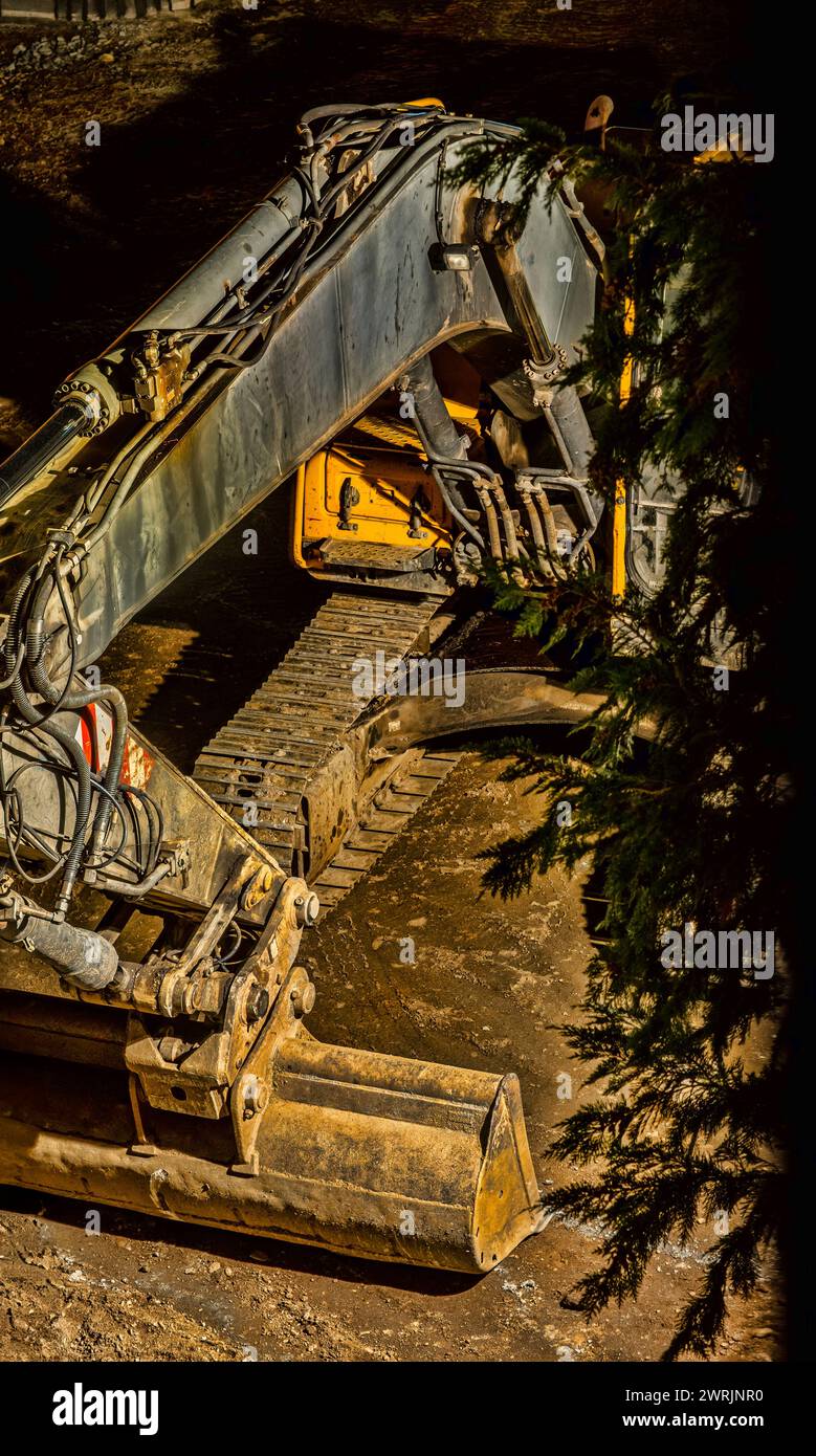 A yellow digger excavator parked during the night on a construction ...
