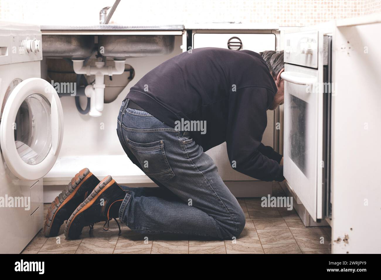 Older man disassembling apartment kitchen out of service Stock Photo ...