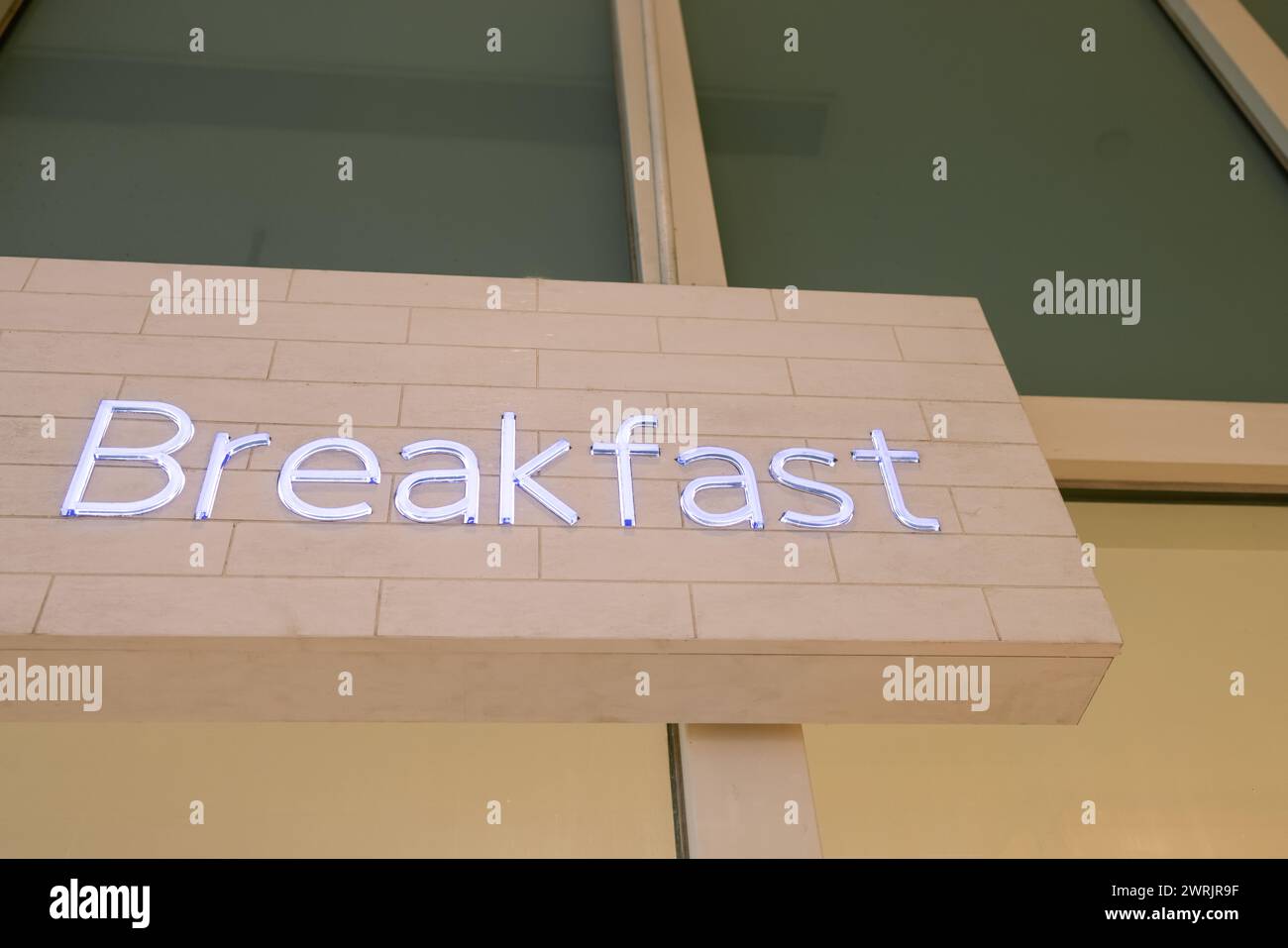 The inscription Breakfast in white letters on the neutral wall invites ...