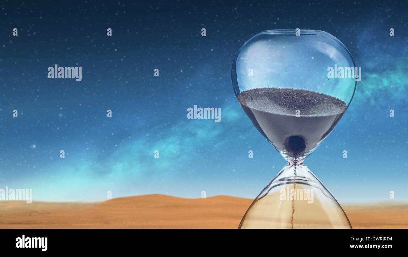 Flowing sand in the hourglass with a night scene background. Time ...