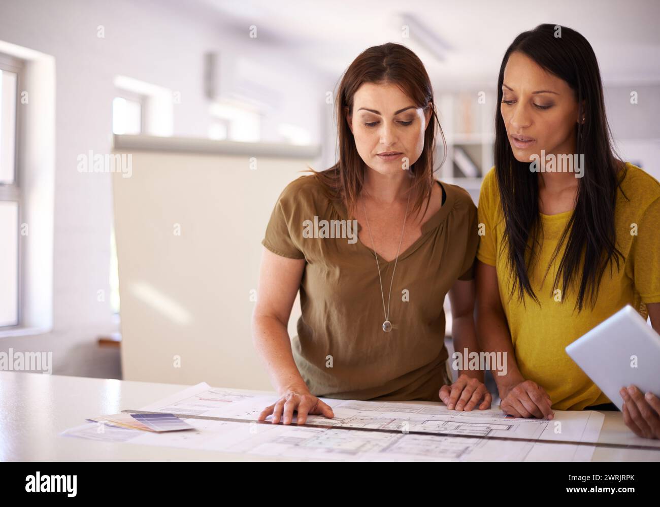 Architect, women and blueprint in meeting at office with reading ...