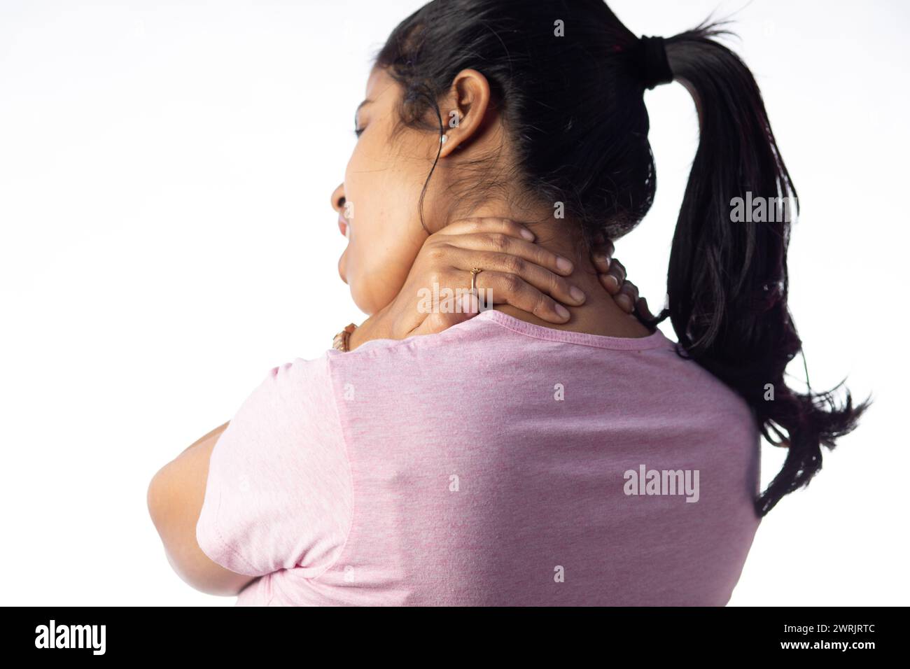 An Indian woman holding her neck for pain showing painful expression on ...