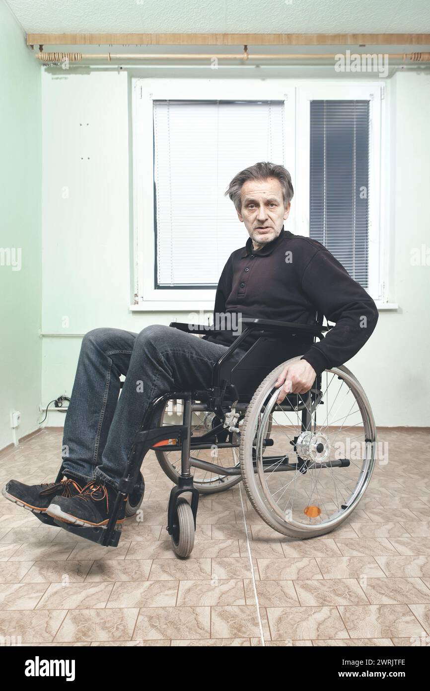 Old disabled man on wheel chair in his poor apartment Stock Photo - Alamy