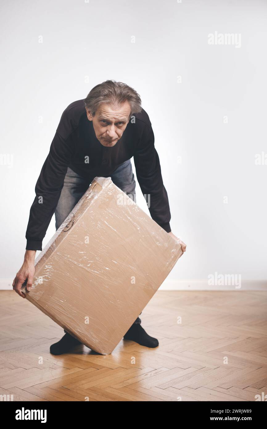 Man unpacking paper box with set of three laminated wood drawers Stock ...