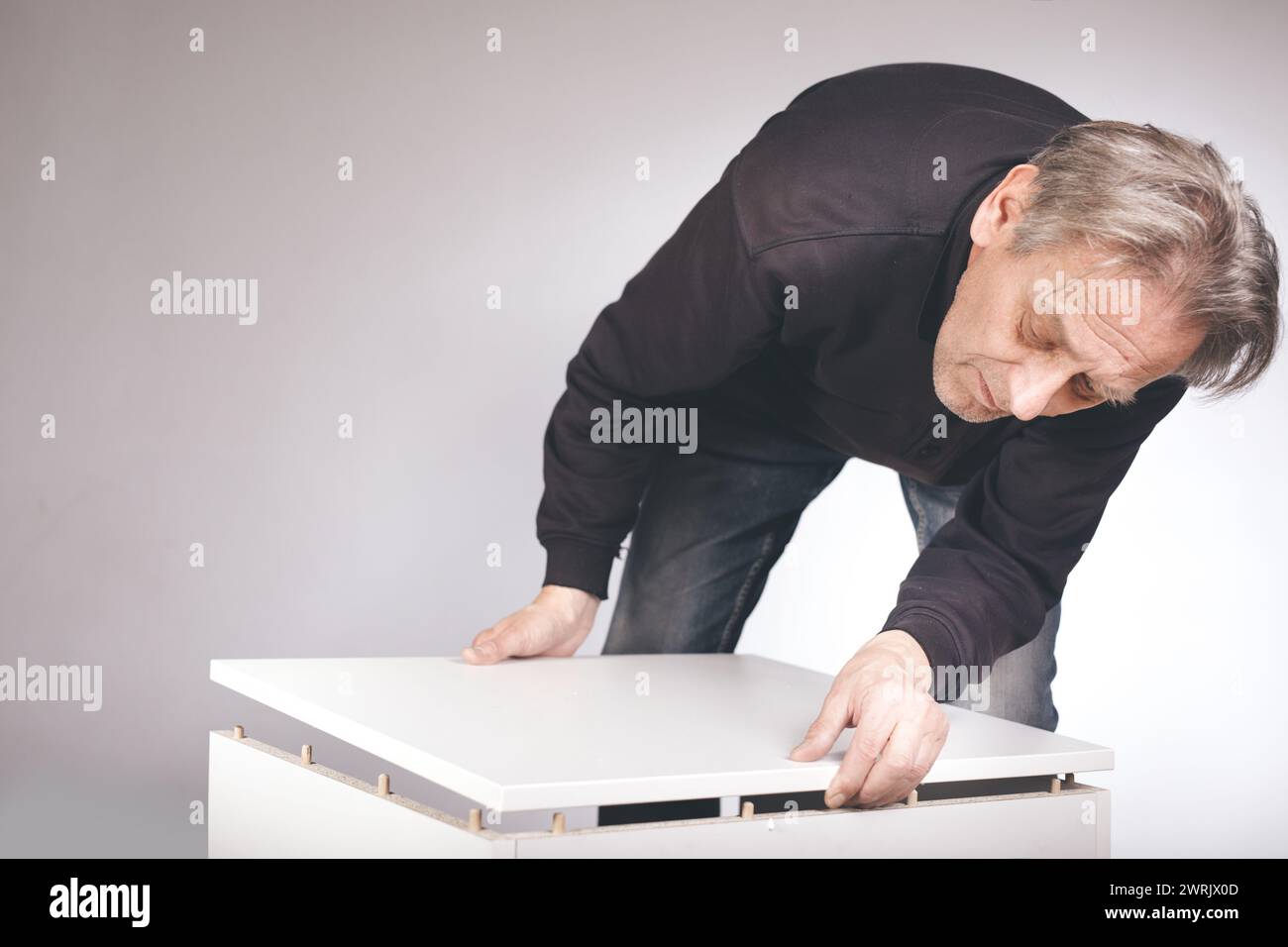 Man assembling set of three laminated wooden drawers Stock Photo - Alamy