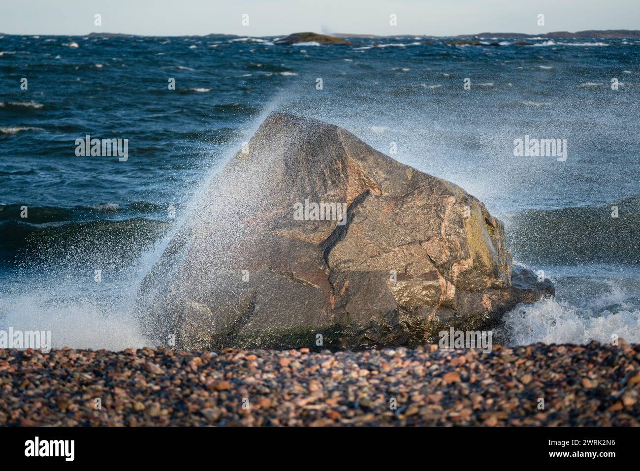 WAVES CRASH ON A LARGE GLACIAL ERRATIC ROCK, BALTIC SEA: Stormy waves crash on a large glacial ...