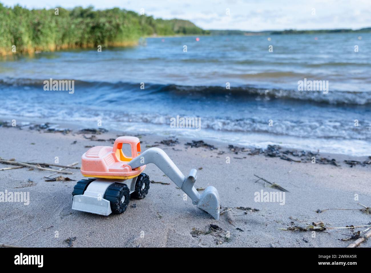 DIGGER PLASTIC TOY LEFT ON BEACH: A faded child's toy left abandoned on ...