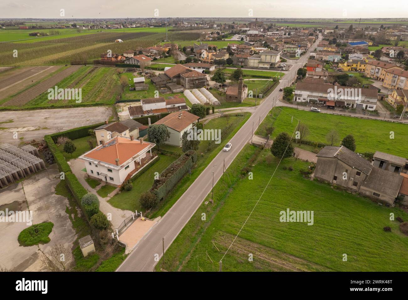 The aerial view showcases a cluster of houses surrounded by fields and ...
