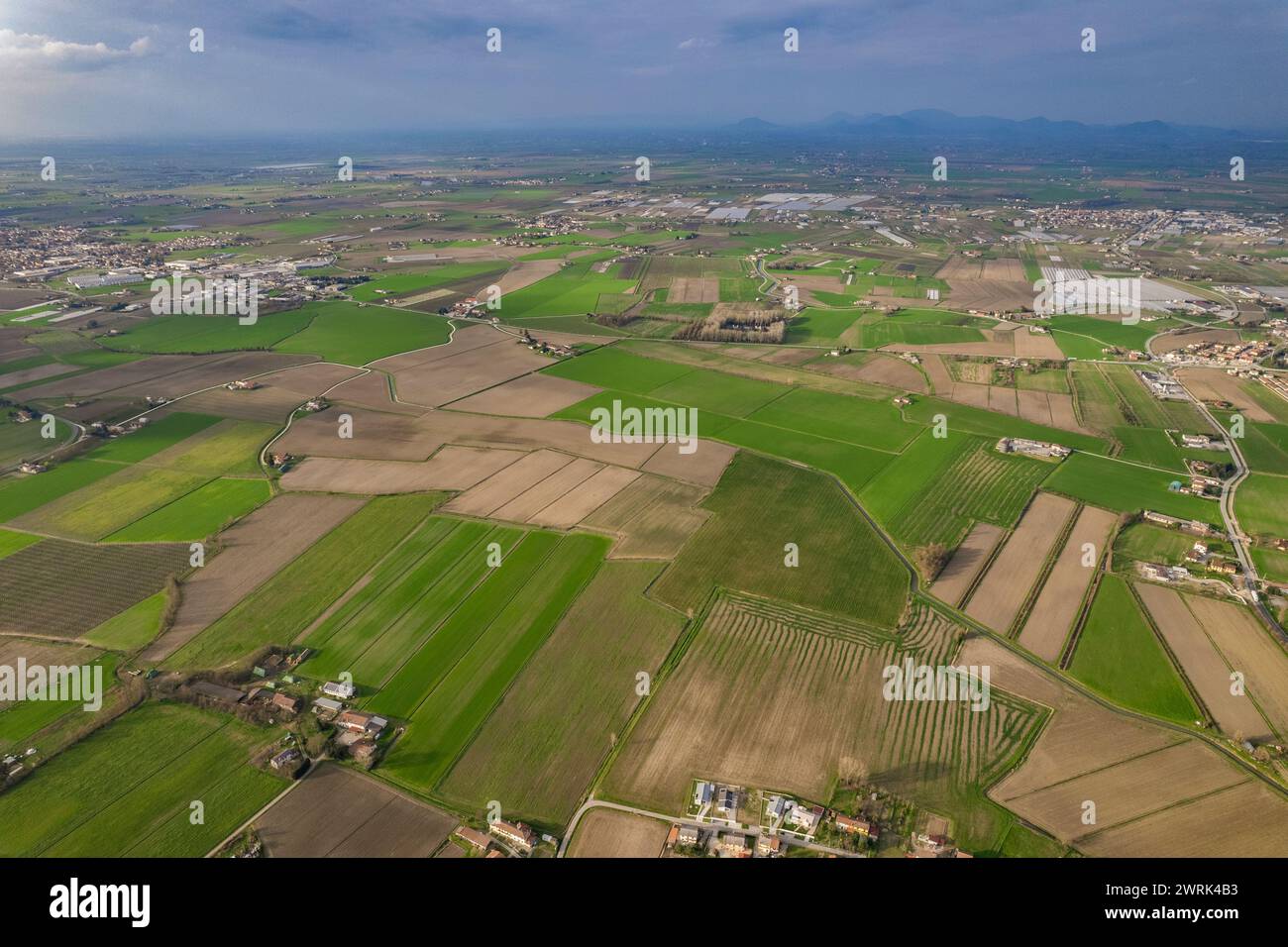 An aerial perspective of a vast green field stretching into the ...