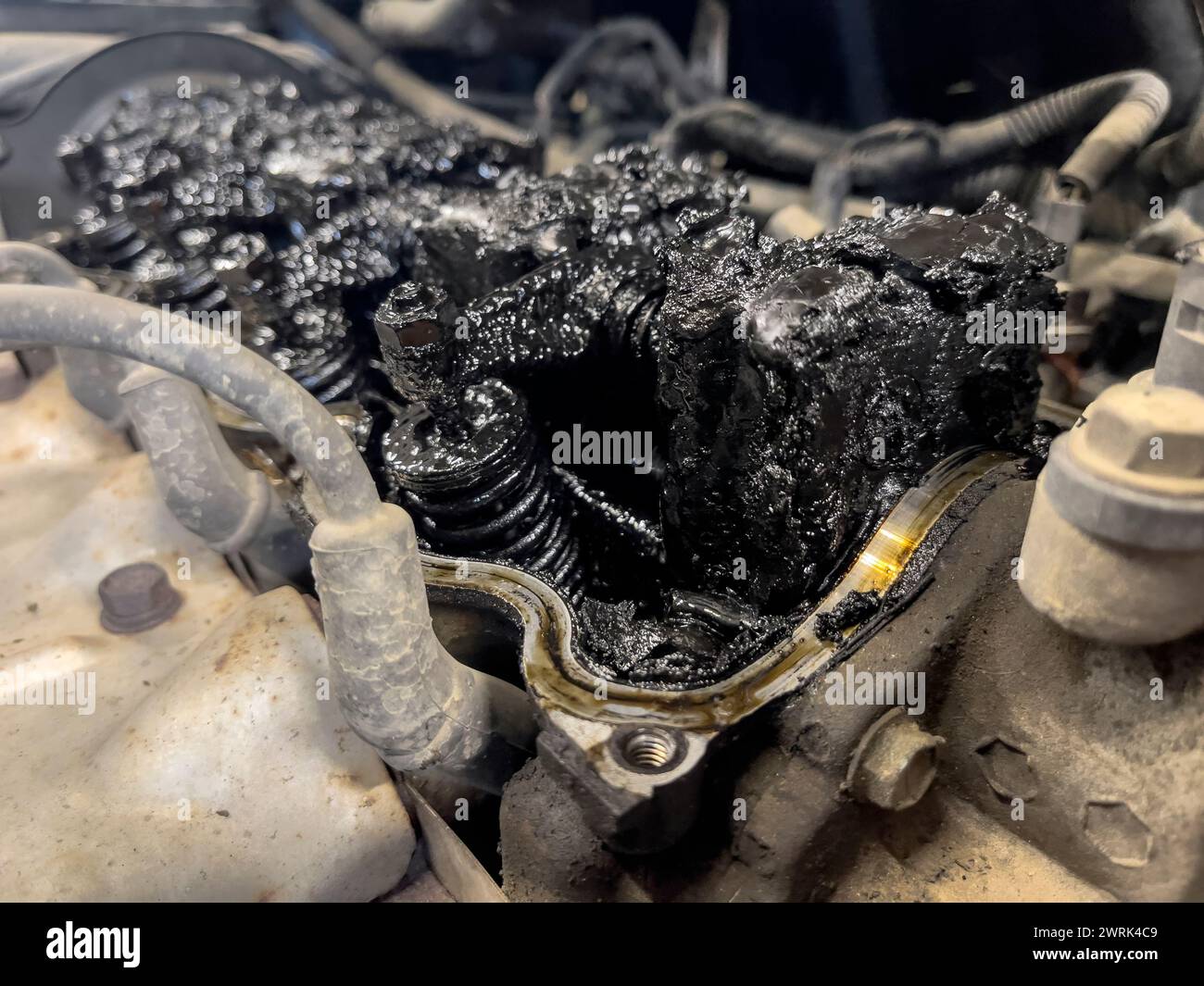 Car engine caked with residues and tar, a symbol of poor maintenance ...