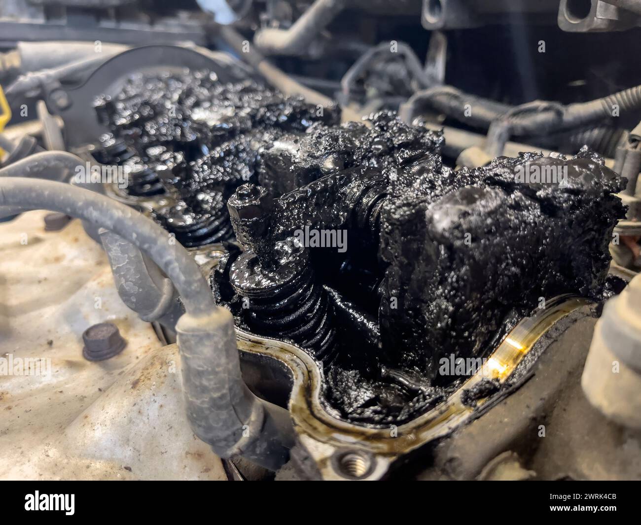 Car engine caked with residues and tar, a symbol of poor maintenance ...